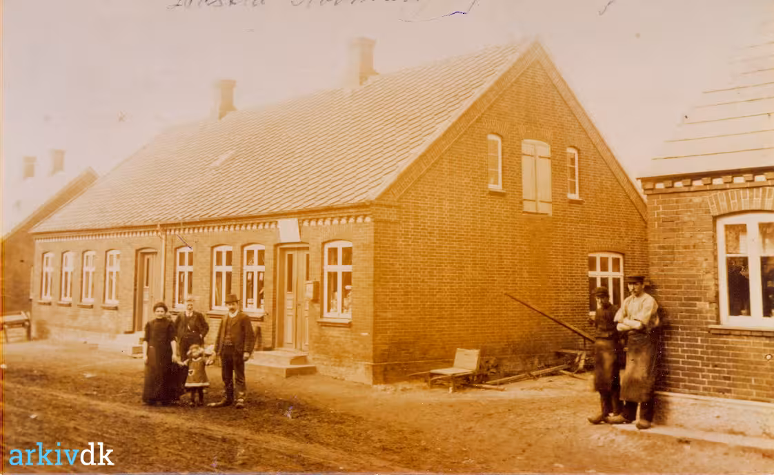 arkiv.dk | 1910 ca Åsted Byvej 6. Købmand Jens Rusberg Jepsen foran forretningen med kone ...