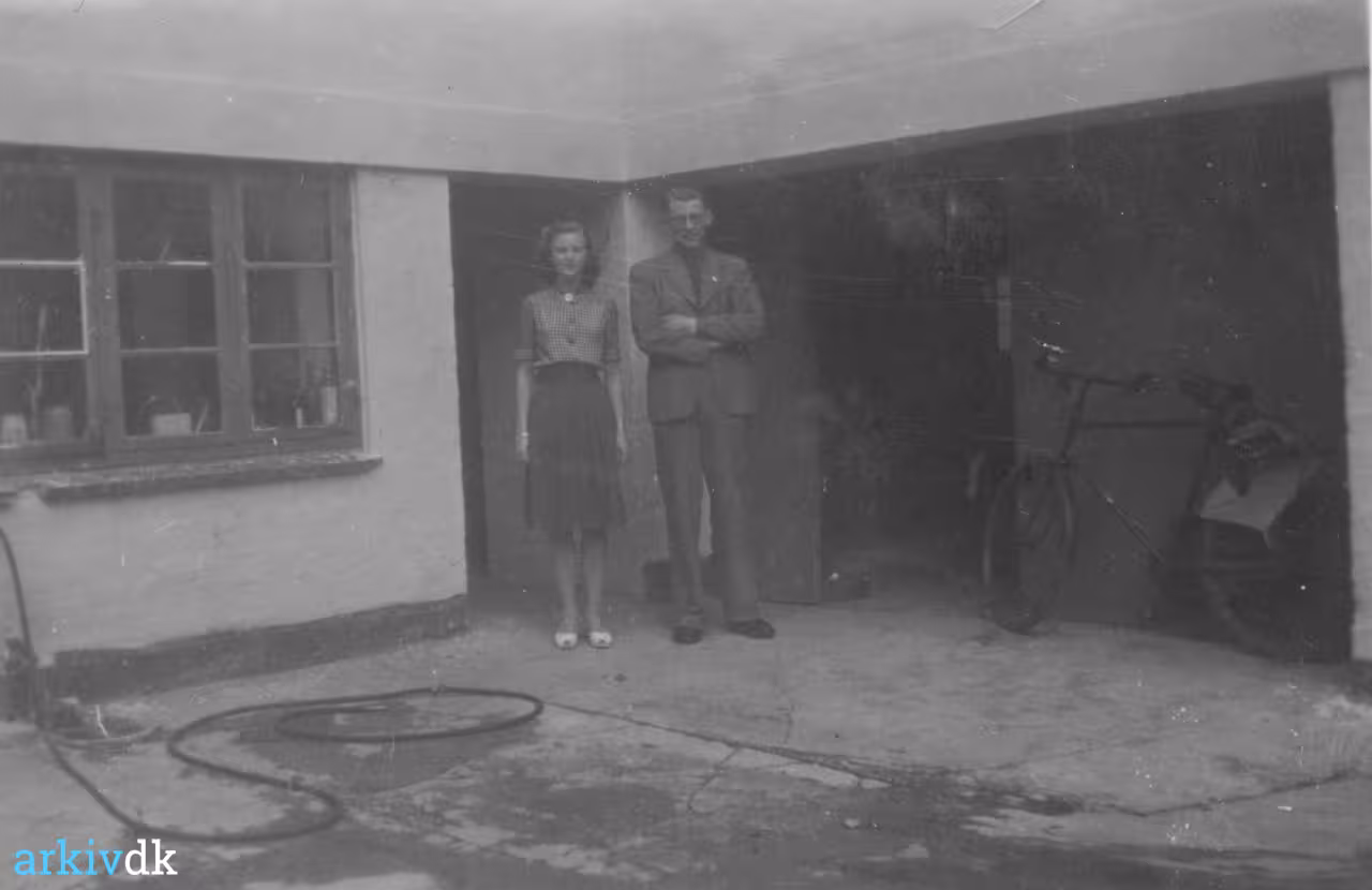 arkiv.dk | Kvinde og mand stående på gårdsplads Anne Margrethe Larsen kaldet Gete og Hr. Jensen ...