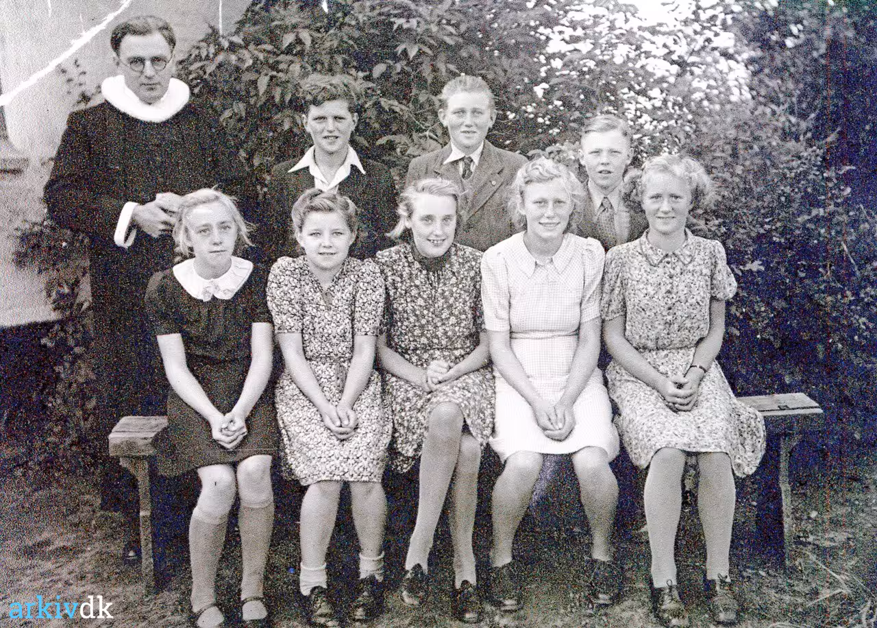 arkiv.dk | 1942 Konfirmation i Junget. Pastor Ove Juul Christensen med 8 konfirmander i haven