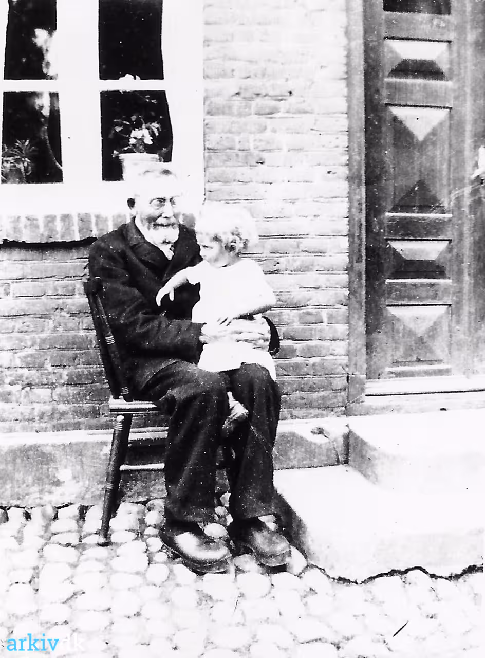 arkiv.dk | Den gamle smed Hans Peter Pedersen siddende træt foran smedjen, Søndergade 13 Gelsted ...