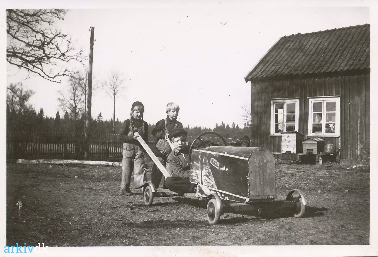 arkiv.dk | Alhed Marie "Søster" Larsen og Johannes "Jonas Larsen skubber Jens Syrak Larsen i en ...
